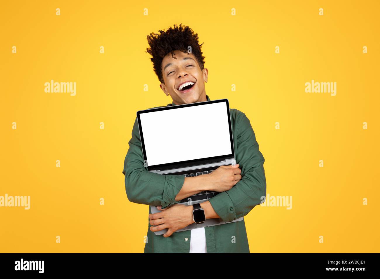 Overjoyed black guy hugging laptop with white blank screen Stock Photo ...