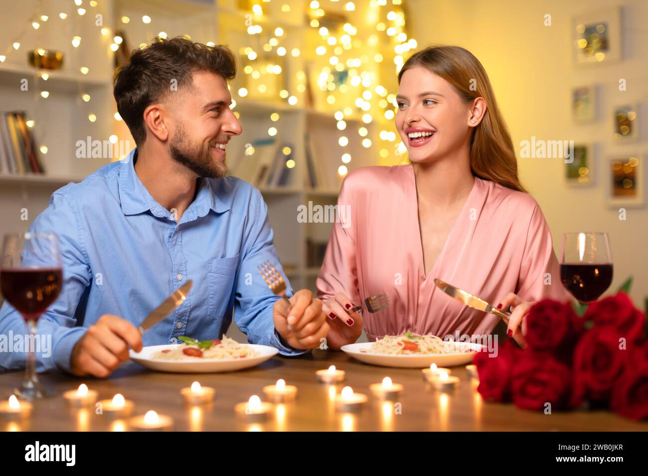 Joyful couple dining with wine and roses, enjoying conversation Stock ...