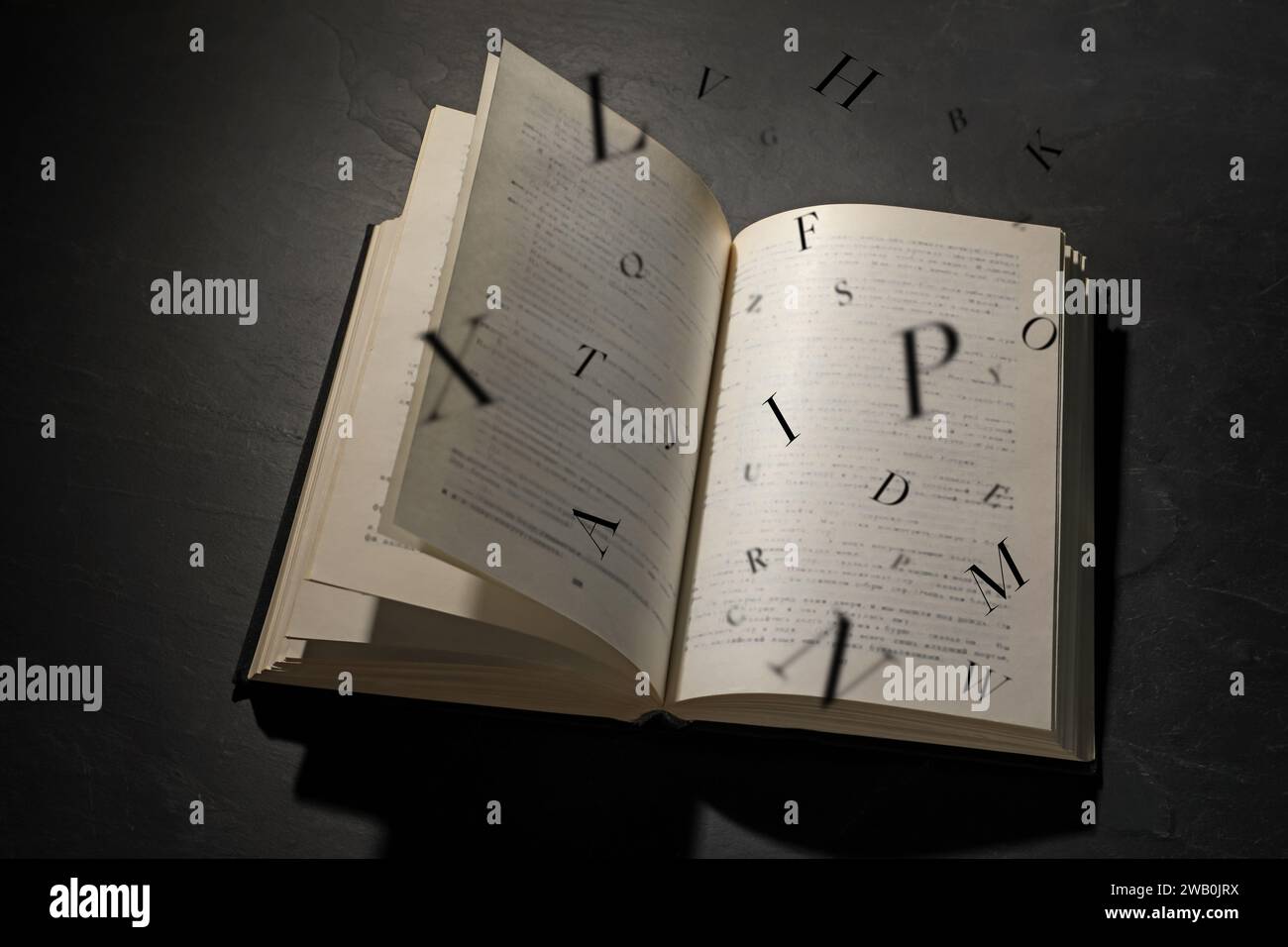 Open book with letters flying out of it on black background Stock Photo ...