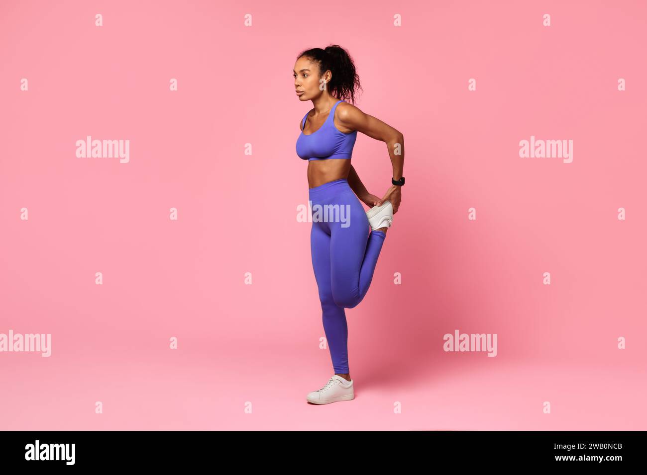 Fit African Woman Stretching Holding Leg Behind On Pink Background ...