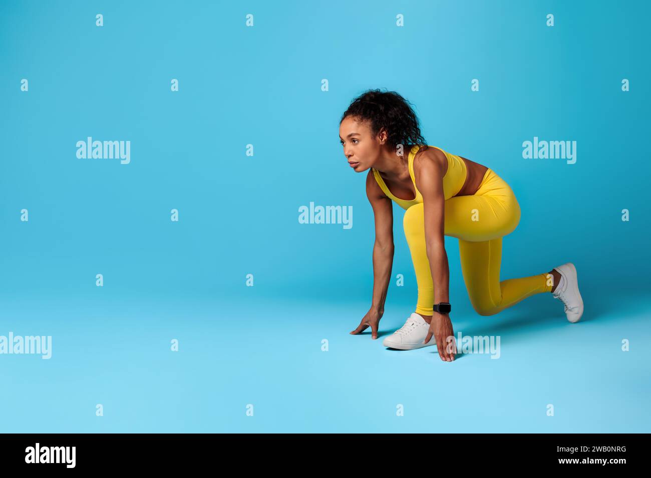 Black Lady Runner Standing In Crouch Start Position, Blue Background ...