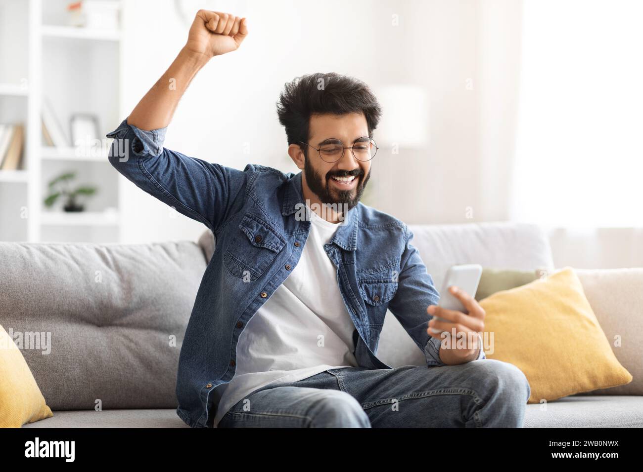 Great News. Overjoyed Indian Man Looking At Smartphone Screen And ...