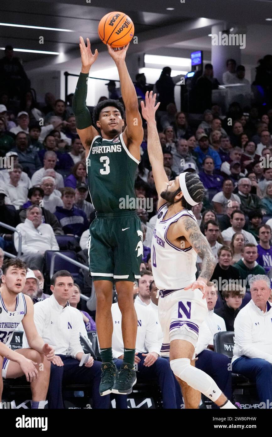 Michigan State guard Jaden Akins, left, shoots over Northwestern guard ...