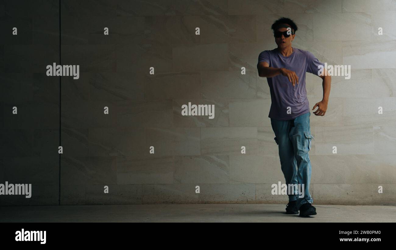 Skilled smart street dancer practice b-boy movement in building with ...