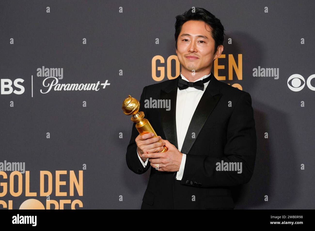 Steven Yeun poses in the press room with the award for best performance ...