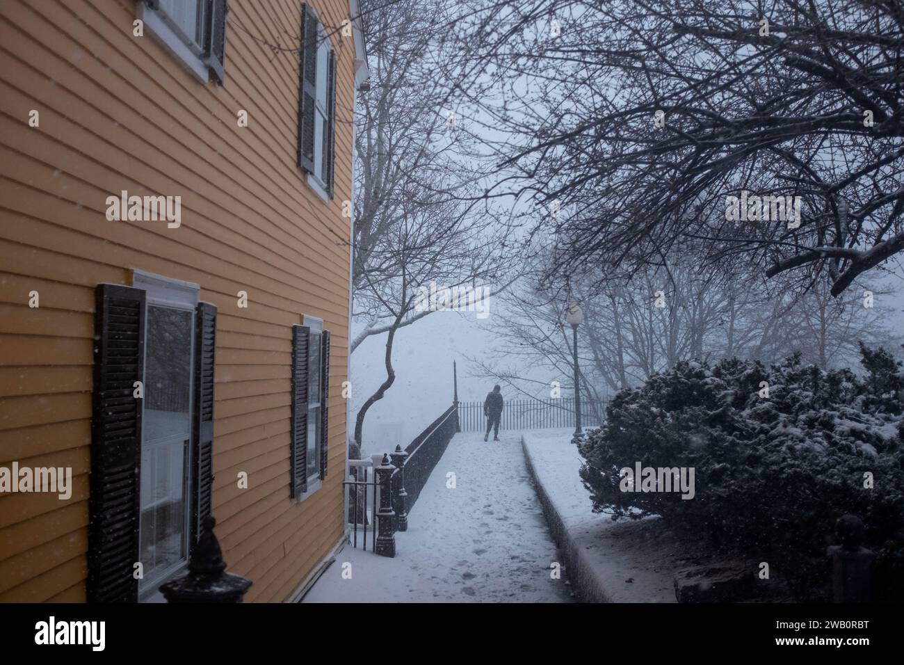 A pedestrian walks along a snow covered park, Sunday, Jan. 7, 2024, in ...