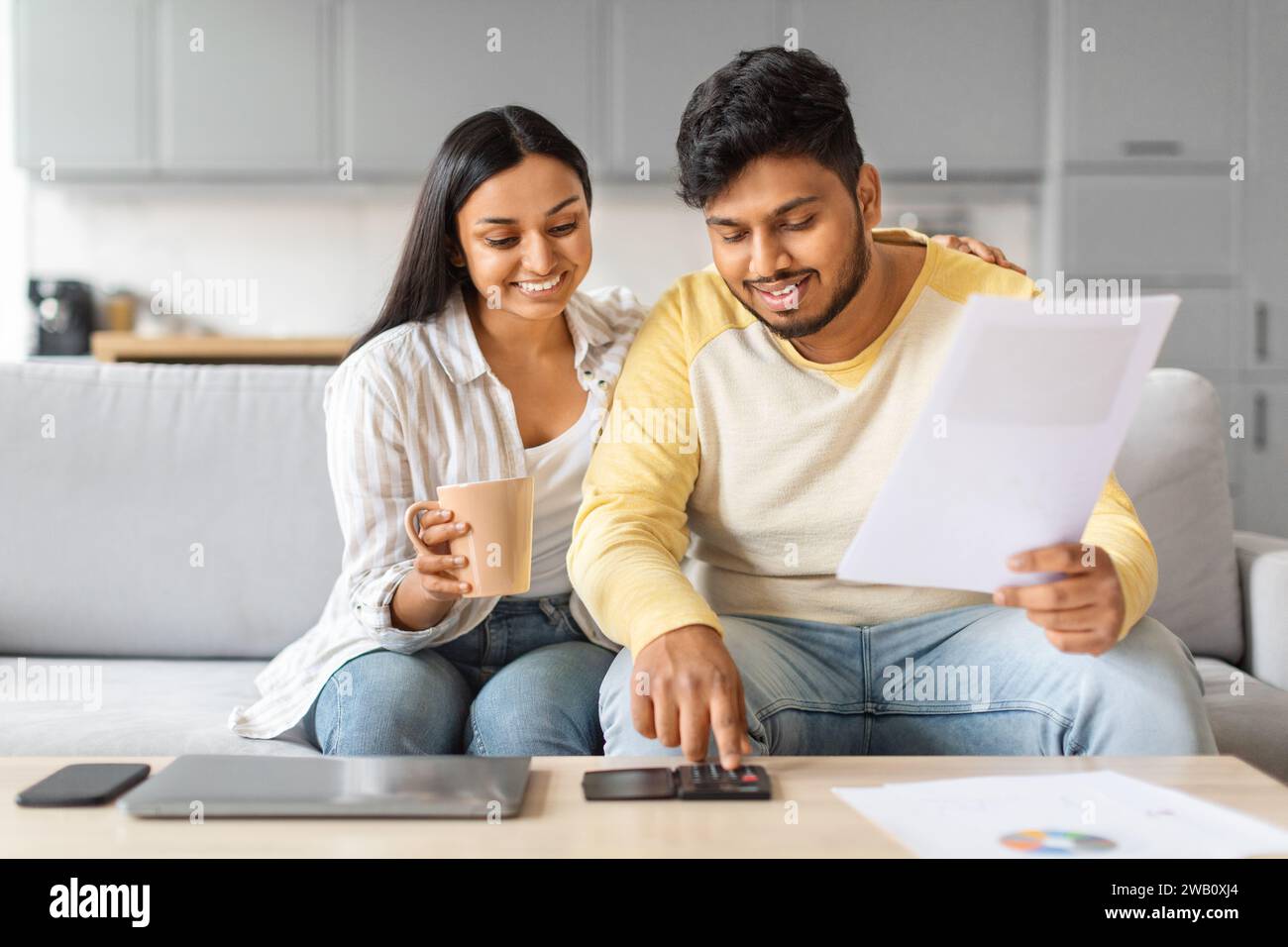 Smiling Indian Couple Checking Financial Documents And Calculating ...