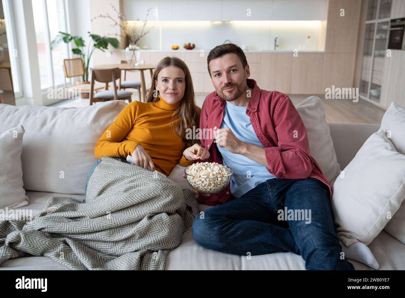 Pleased man woman resting watching TV series together sitting on couch ...