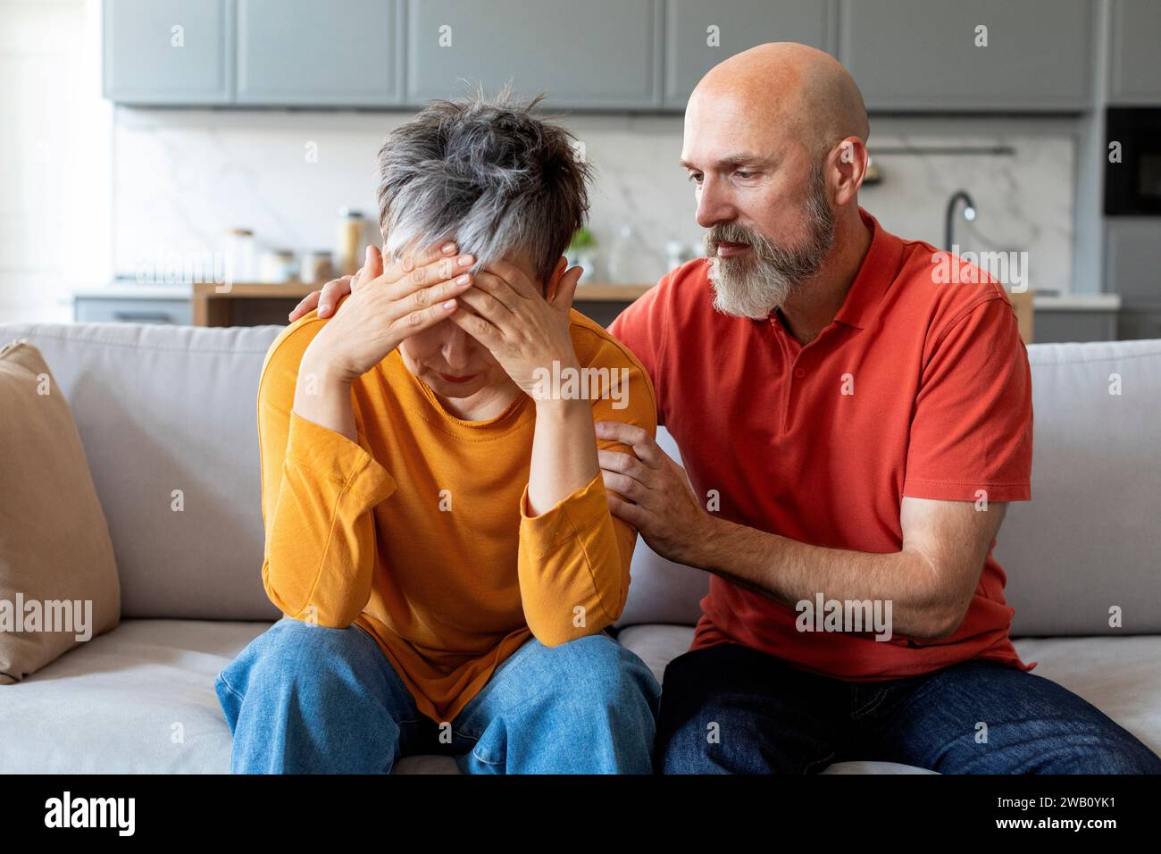 Caring elderly husband comforting his crying wife at home Stock Photo ...