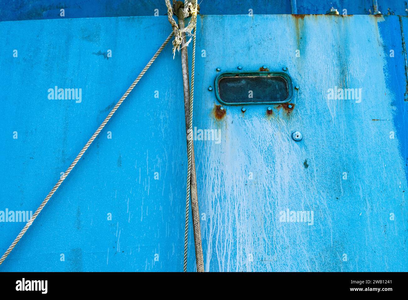 Small window in the hull of a blue fishing boat Stock Photo - Alamy