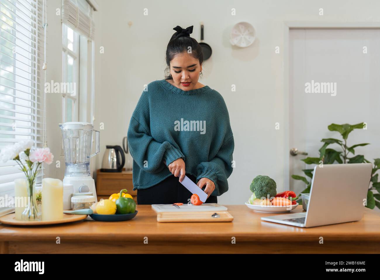 Fat woman cooking in kitchen and chopping fresh vegetables on chopping ...