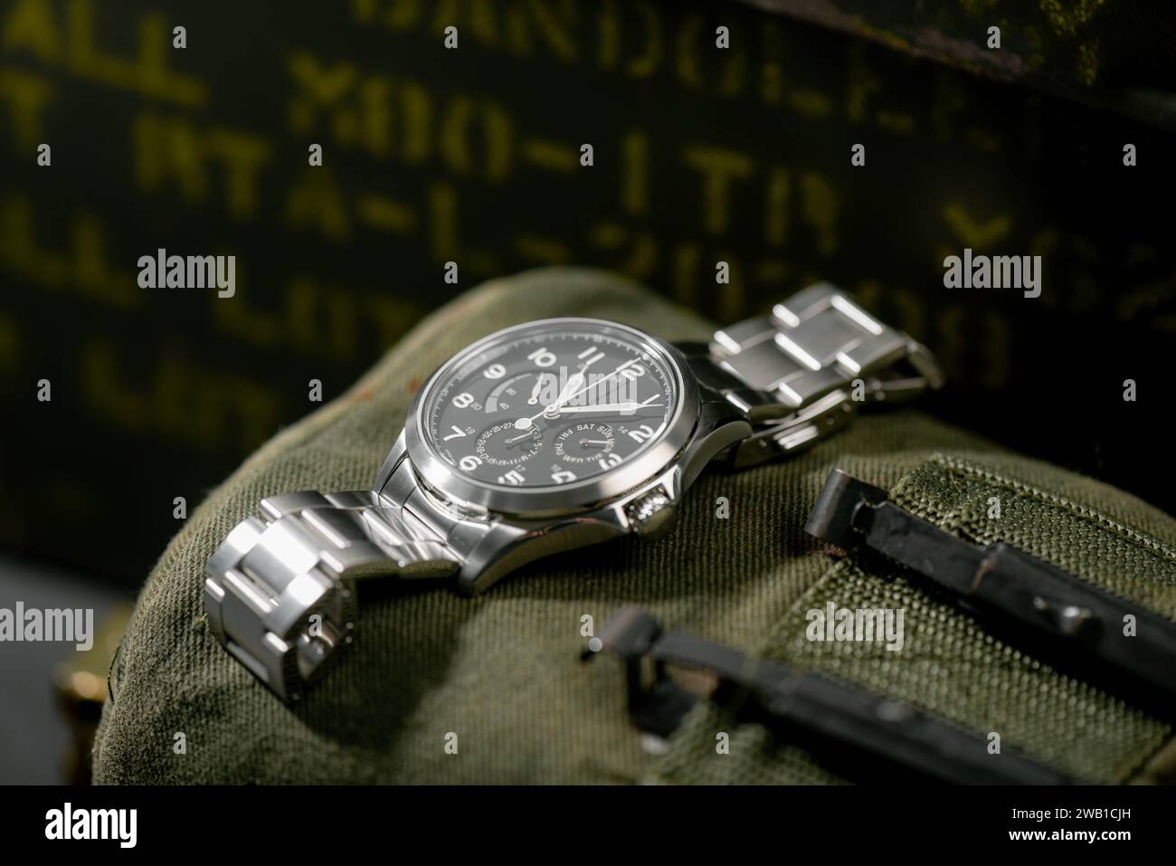 Close up black dial military style wristwatch with stainless steel ...