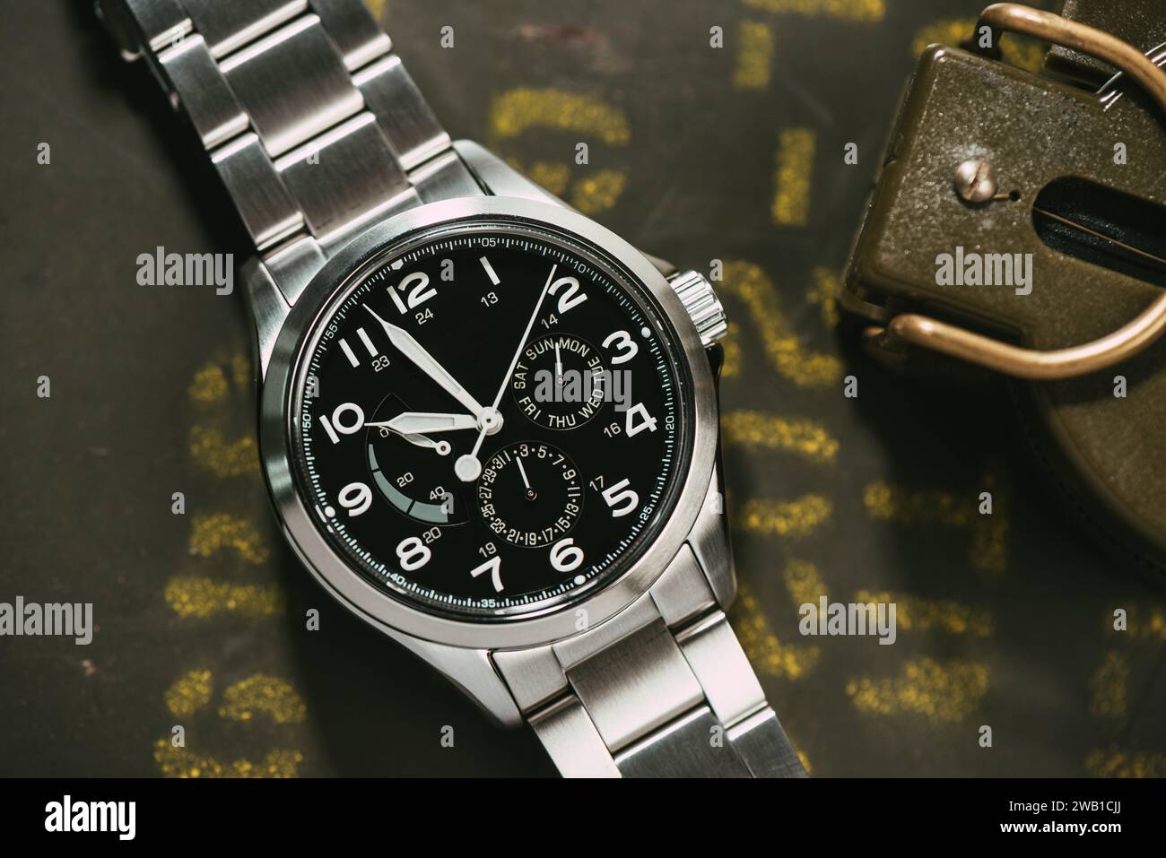 Close up black dial military style wristwatch with stainless steel ...