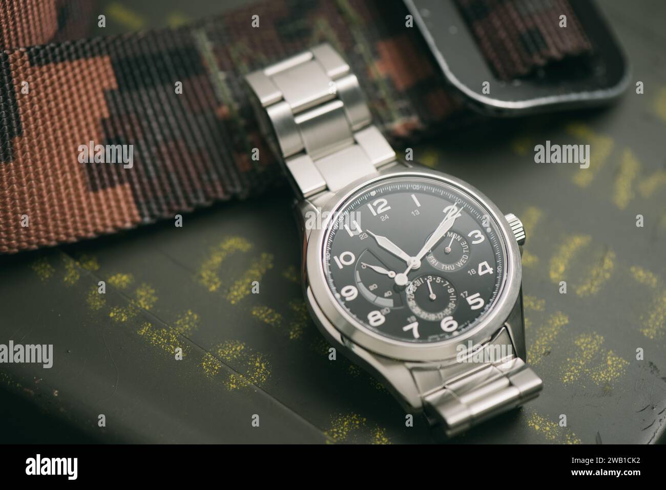 Close up black dial military style wristwatch with stainless steel ...