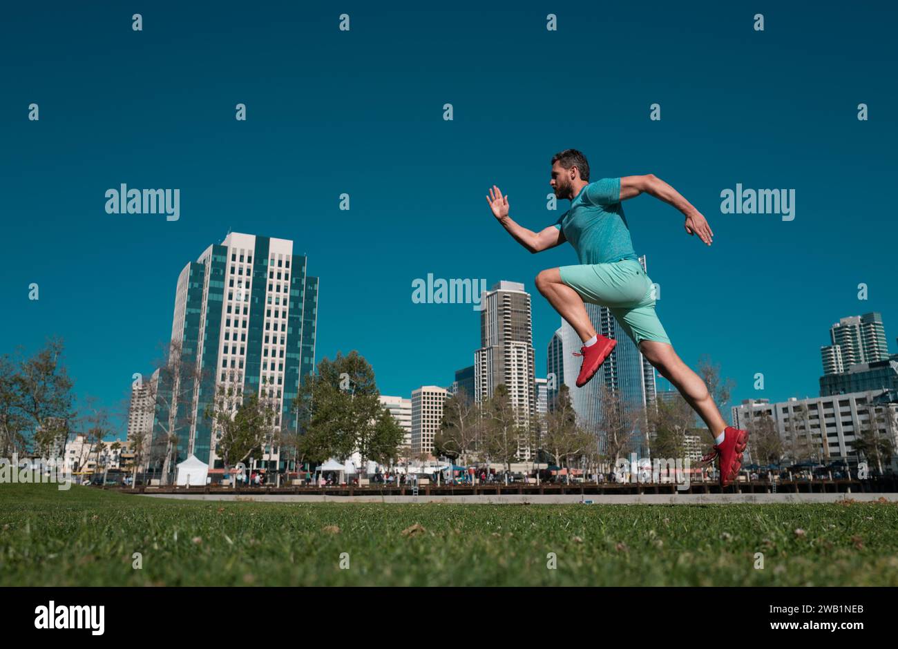 Full length of healthy man running and sprinting outdoors near city ...