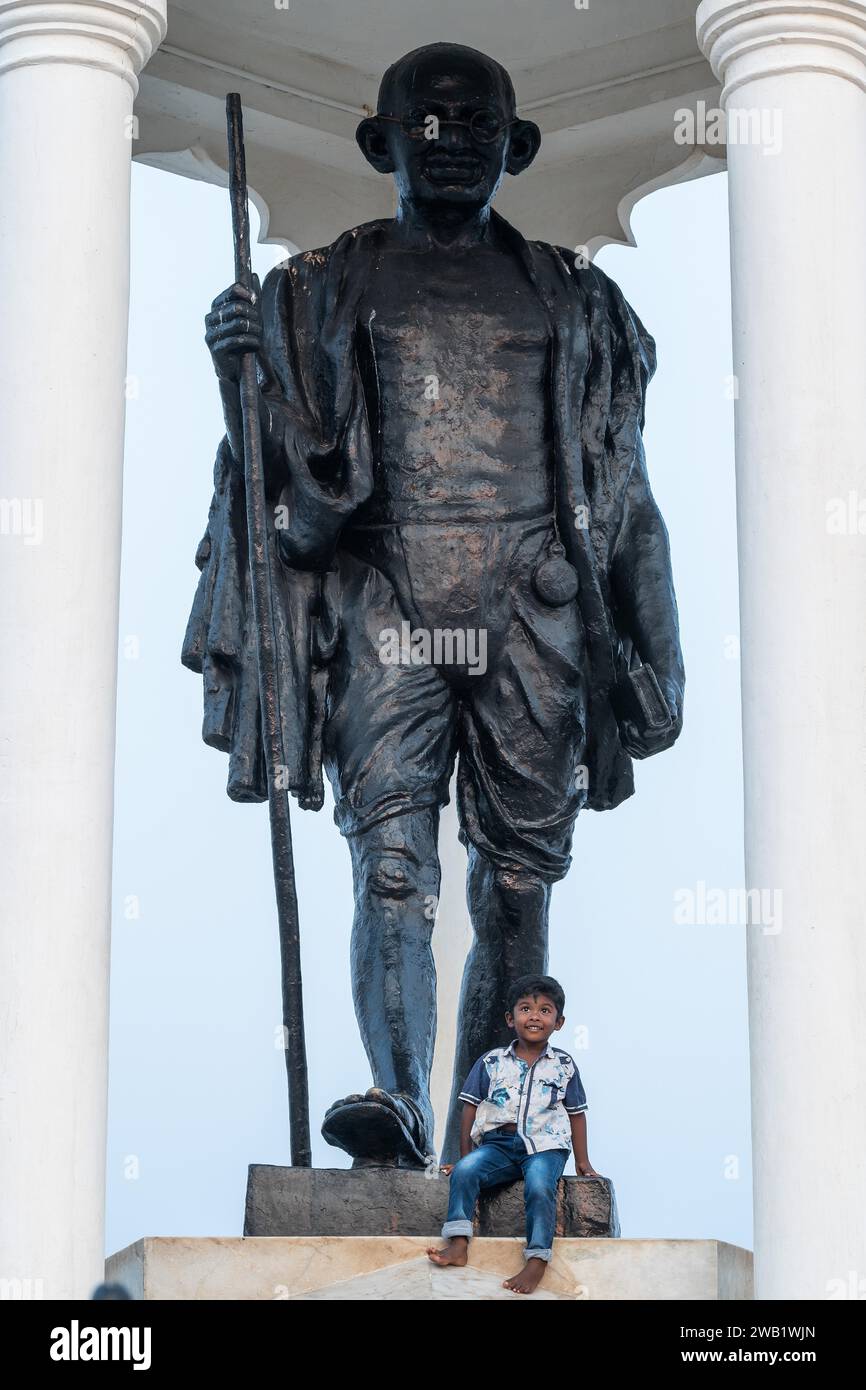 Child at the foot of a Mahatma Gandhi monument, statue, former French ...