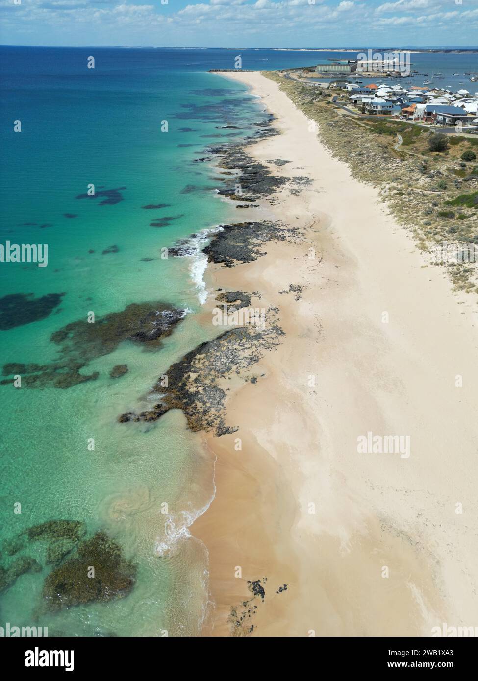 A picturesque coastal beach with crystal clear water stretching across ...