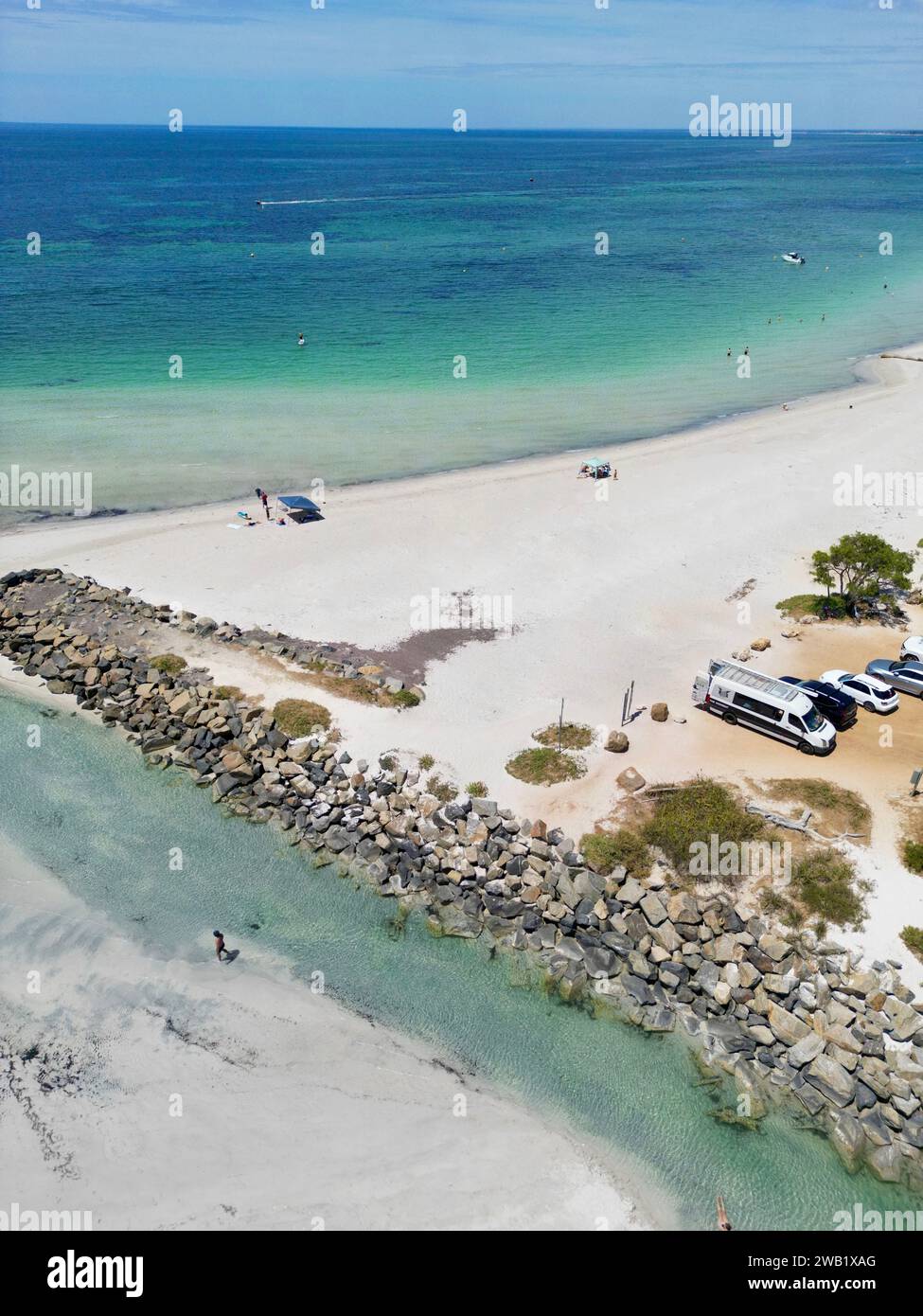 A picturesque coastal beach with crystal clear water stretching across ...