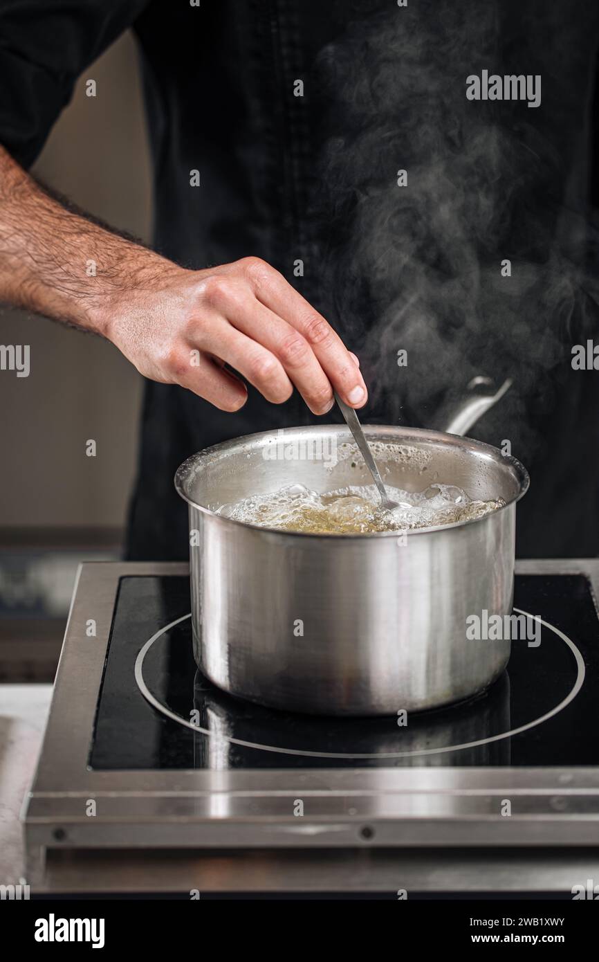Chef boiling water in a steel pot Stock Photo - Alamy