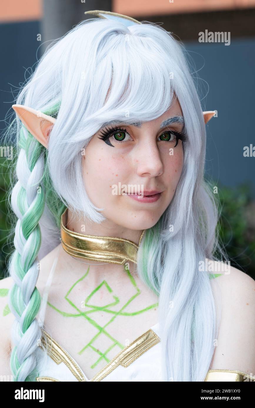 A Caucasian female cosplayer dressed as an anime character in a white ...