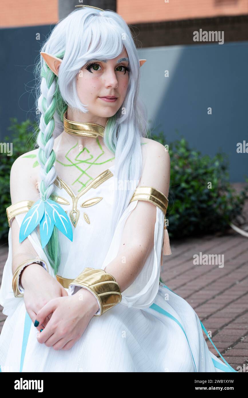 A Caucasian female cosplayer dressed as an anime character in a white ...