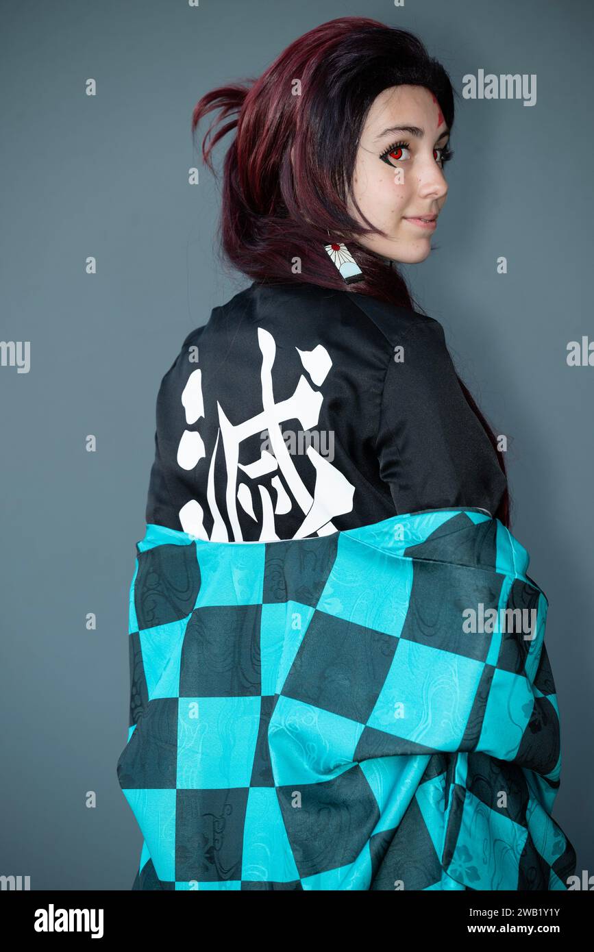 A Caucasian female cosplayer in a blue costume with face paint and red ...