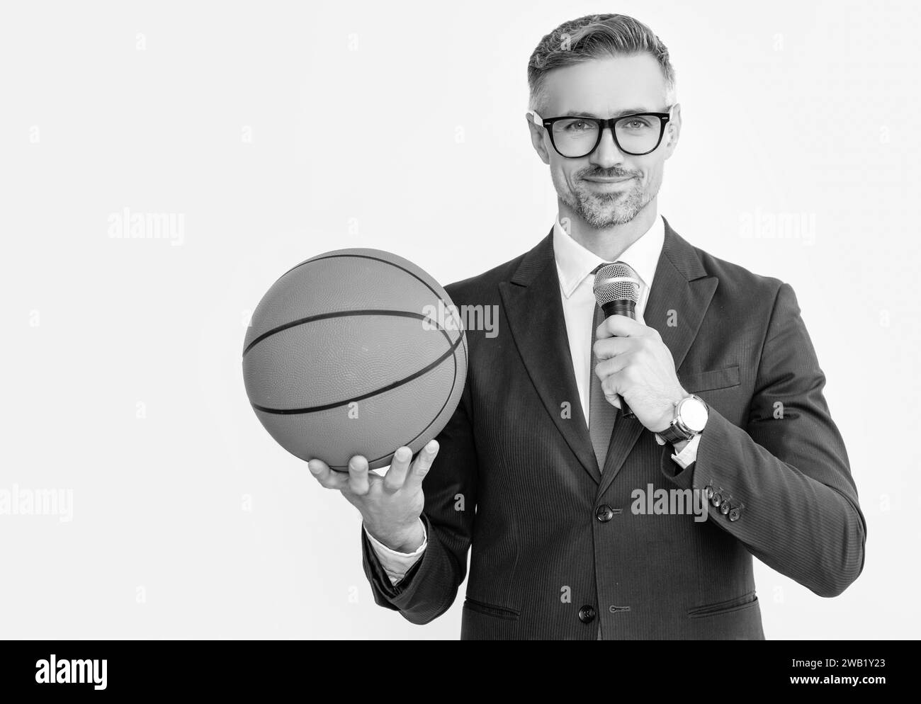 happy mature man in suit hold basketball ball and microphone isolated ...
