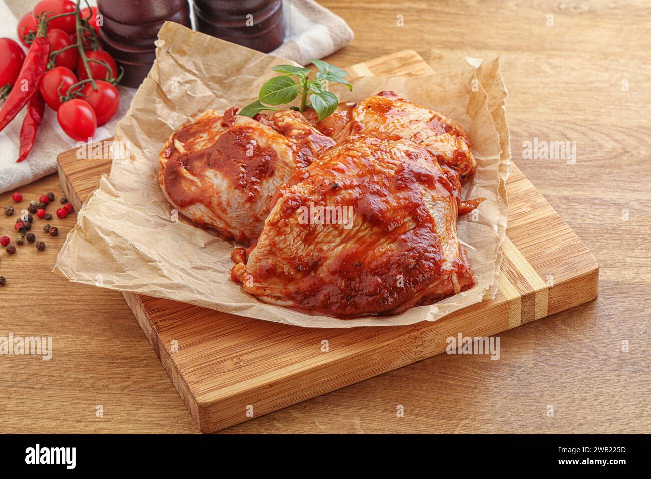 Marinated chicken leg thighs in tomato sauce Stock Photo - Alamy