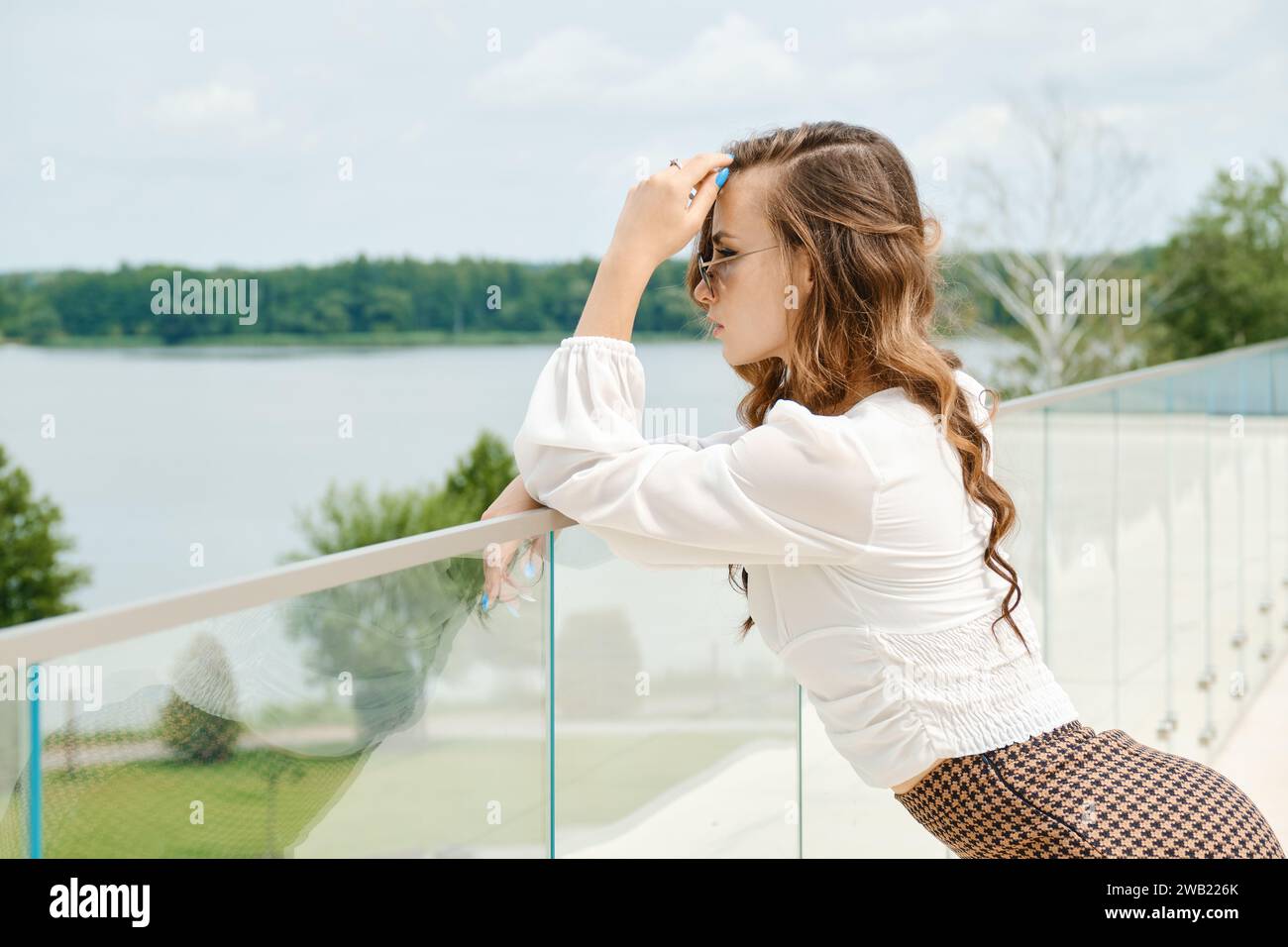 Young woman enjoying beautiful view from balcony covering eyes with ...