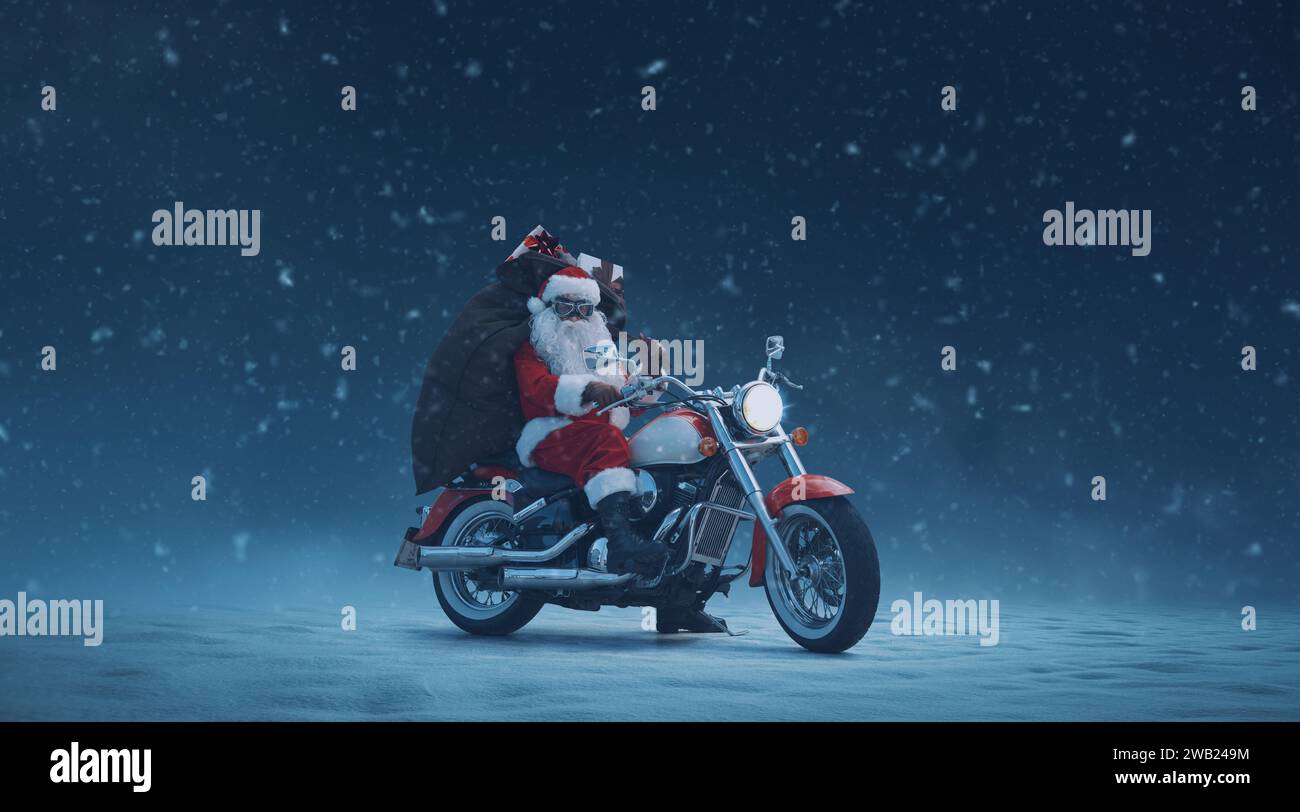 Cool Biker Santa Claus posing on a fast motorbike under the snow and ...
