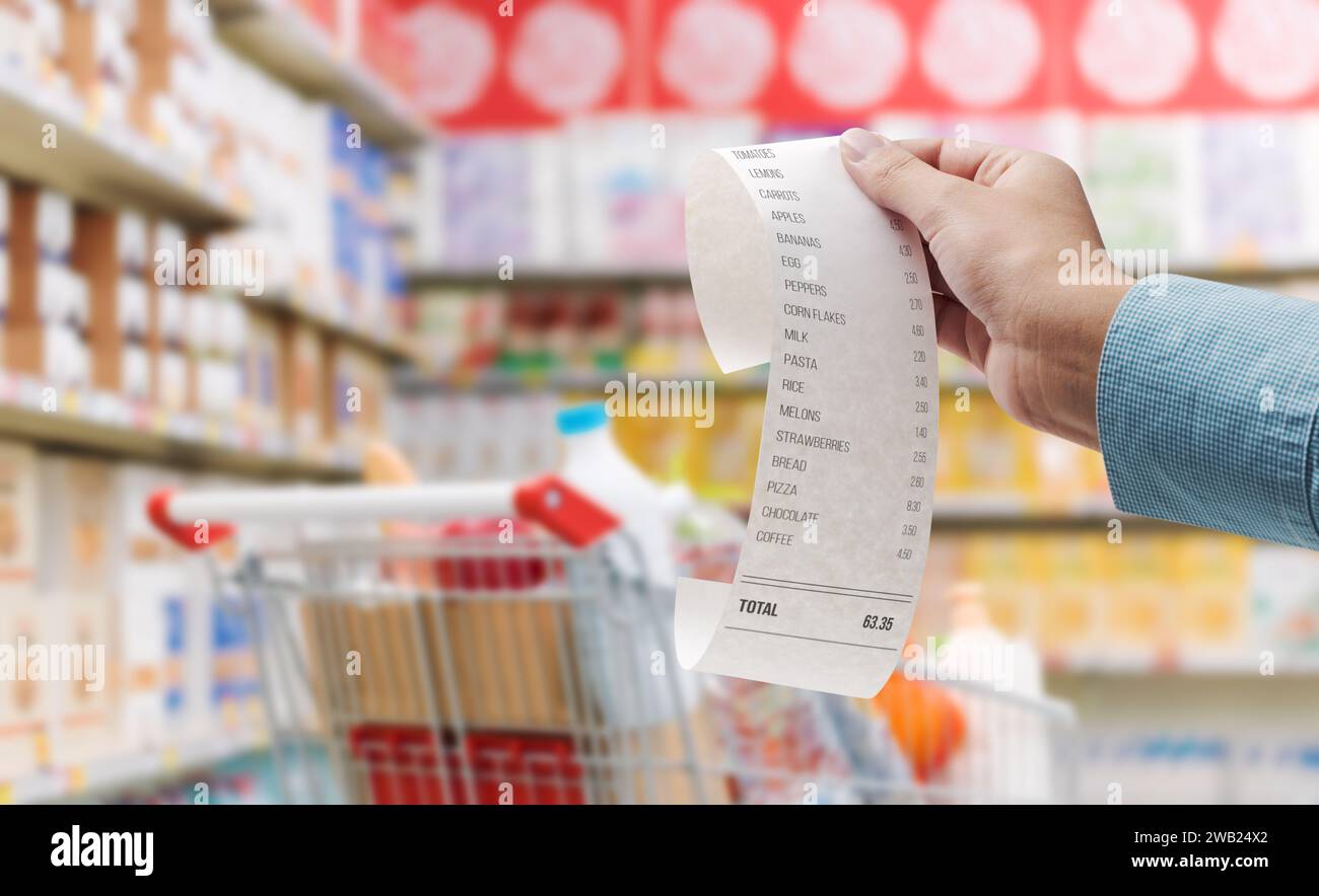 Customer showing a long grocery receipt and supermarket interior in the ...