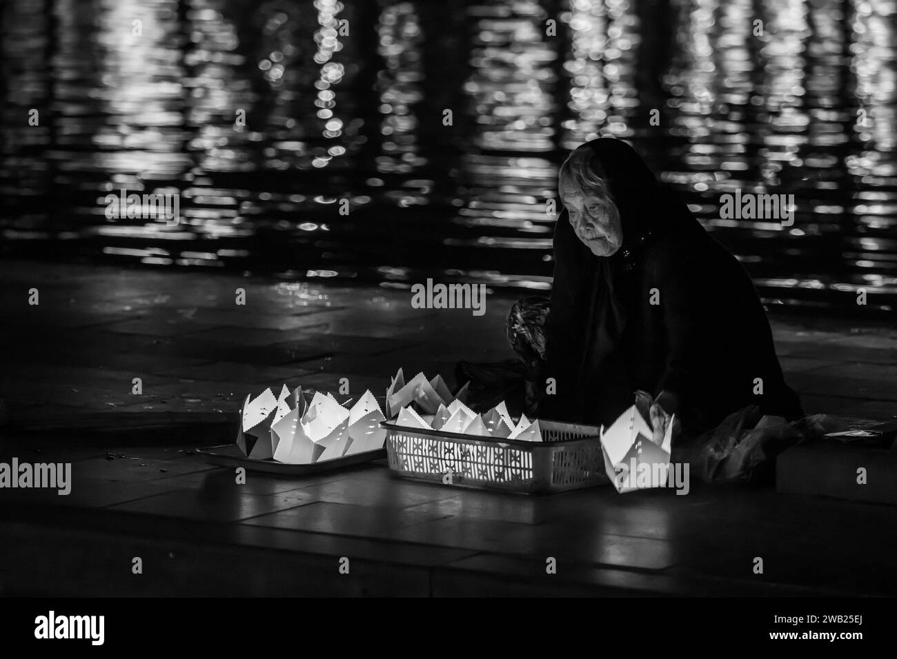 Old poor woman is selling lantern and candles in Hoi An Vietnam Stock ...