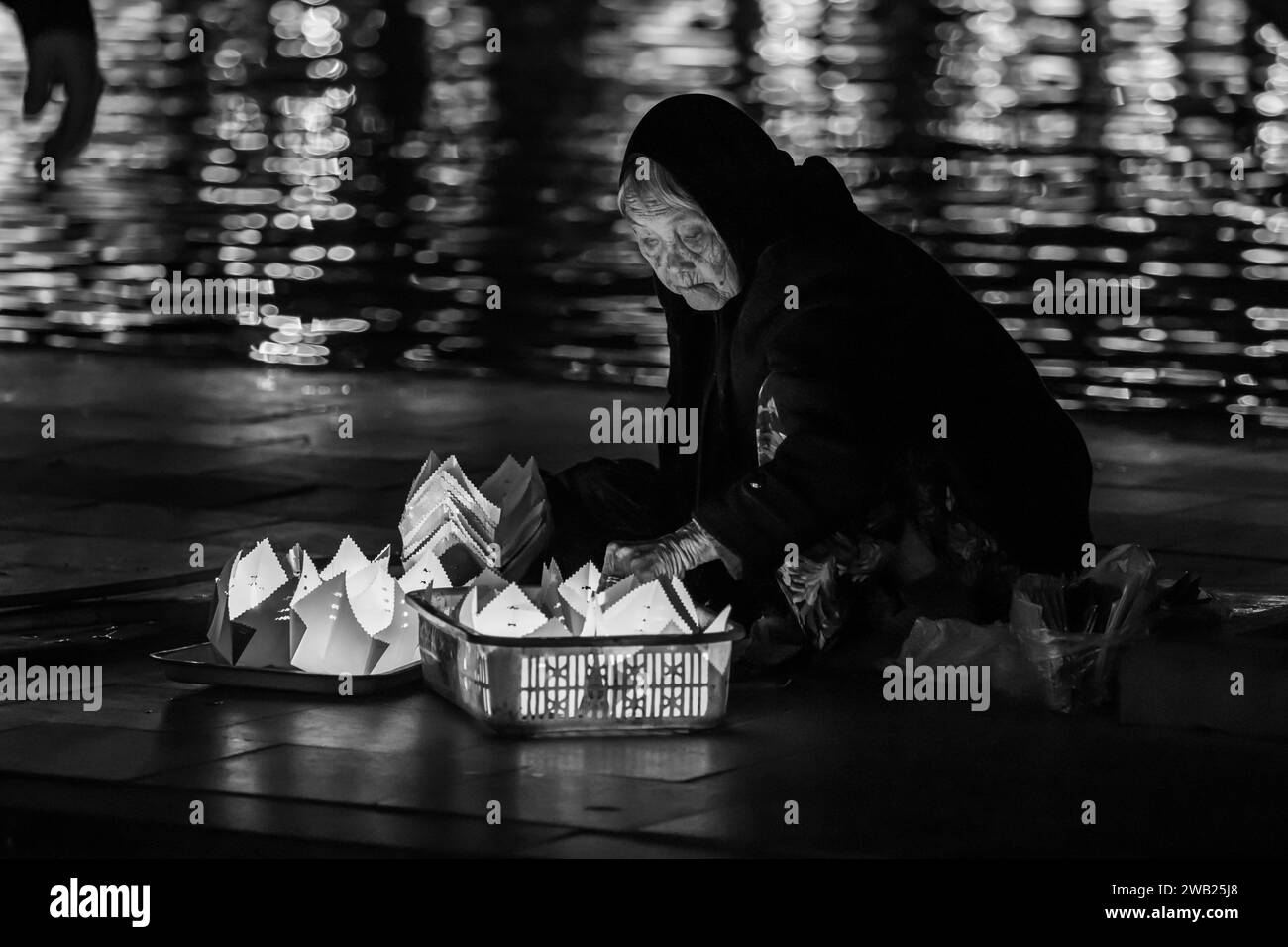Old poor woman is selling lantern and candles in Hoi An Vietnam Stock ...