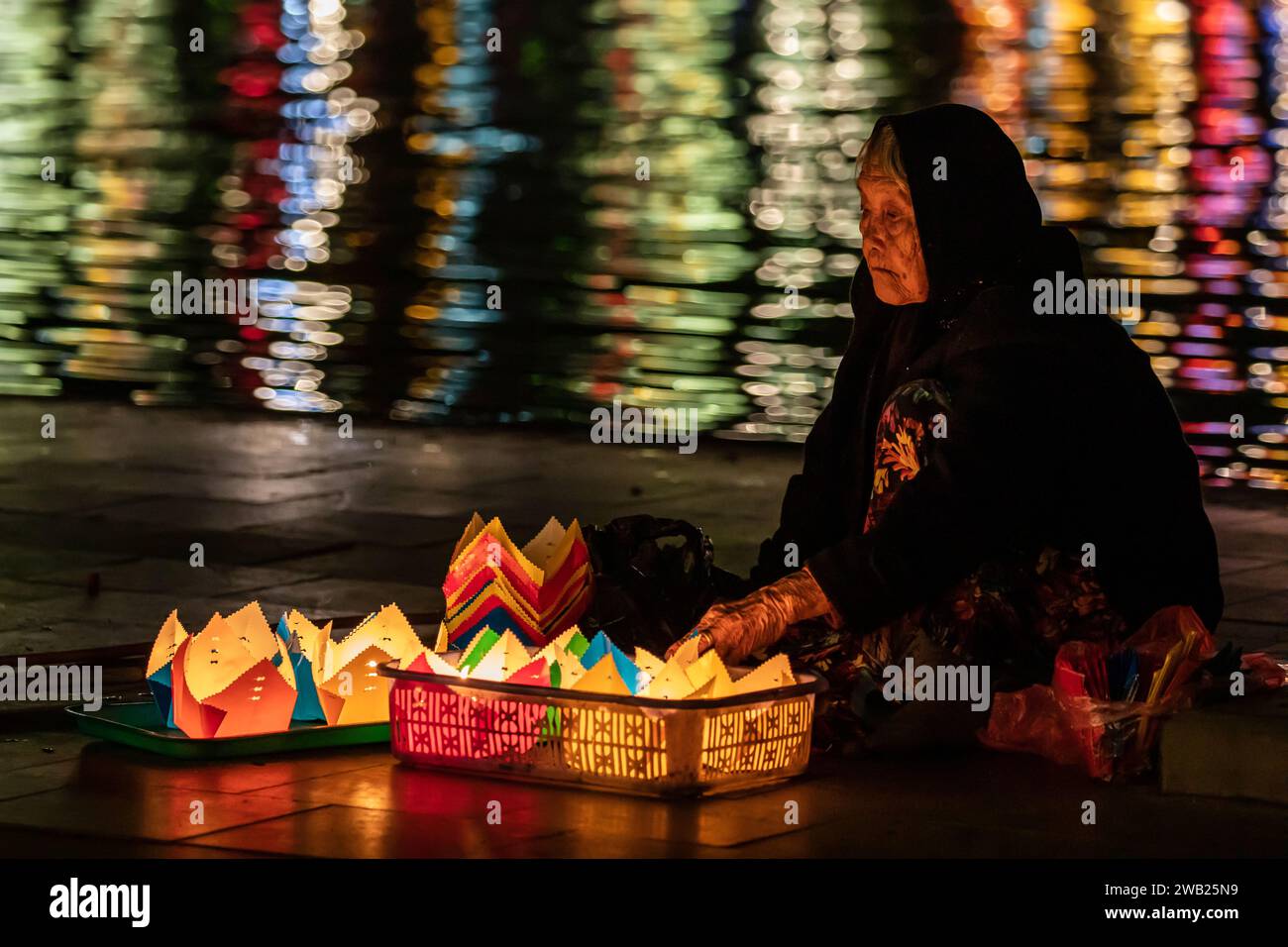 Old poor woman is selling lantern and candles in Hoi An Vietnam Stock ...