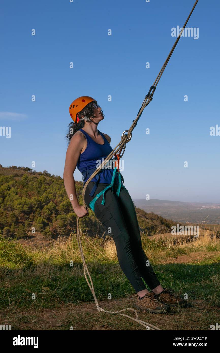 Image of a determined and brave girl climbing an imposing rock face ...