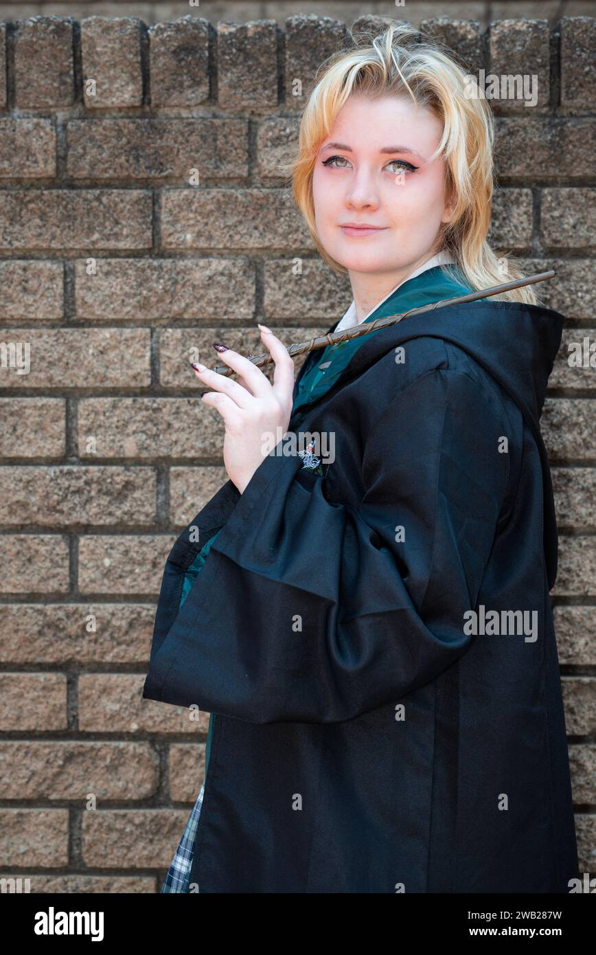A Caucasian blonde female cosplayer dressed as a wizard with a magic ...