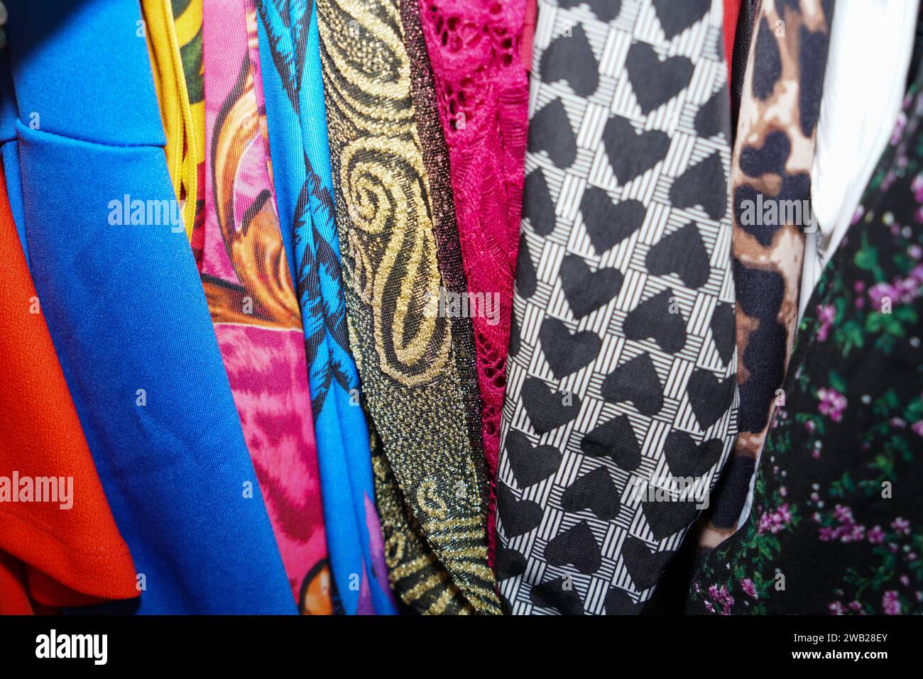 Wardrobe overflowing and colorfully mixed with jackets and pants ...