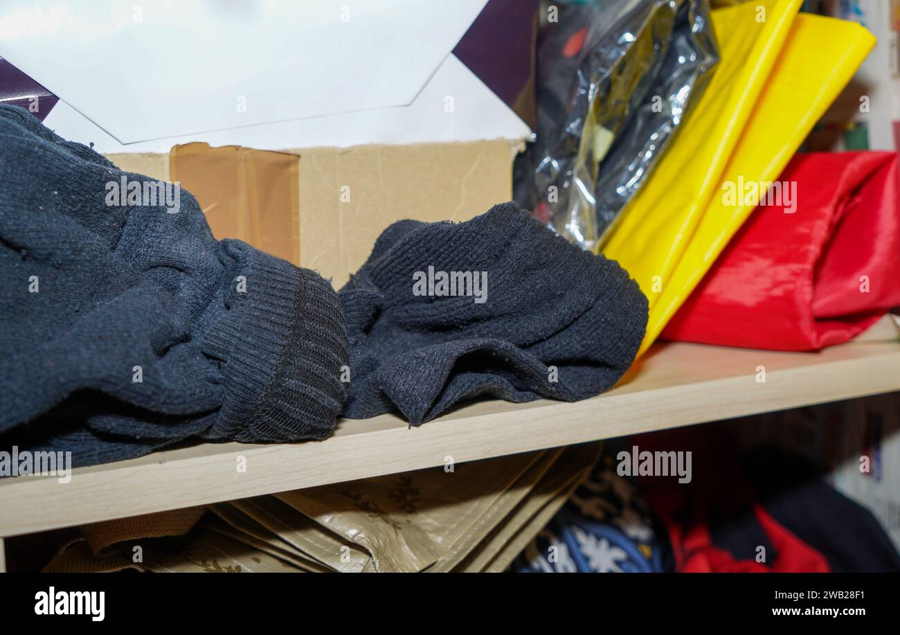 Wardrobe overflowing and colorfully mixed with jackets and pants ...