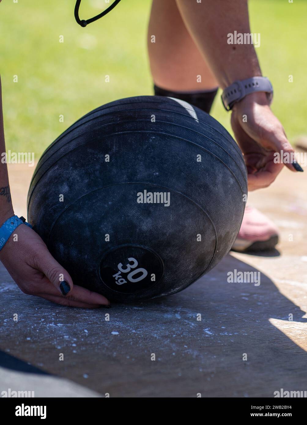 A woman holding a black, weighted ball in their hands Stock Photo - Alamy