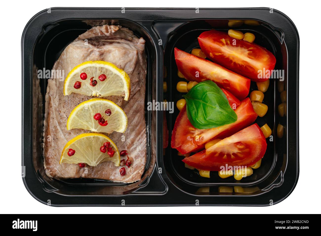 baked fish with sauce and side dish in lunch box on white backgr Stock ...