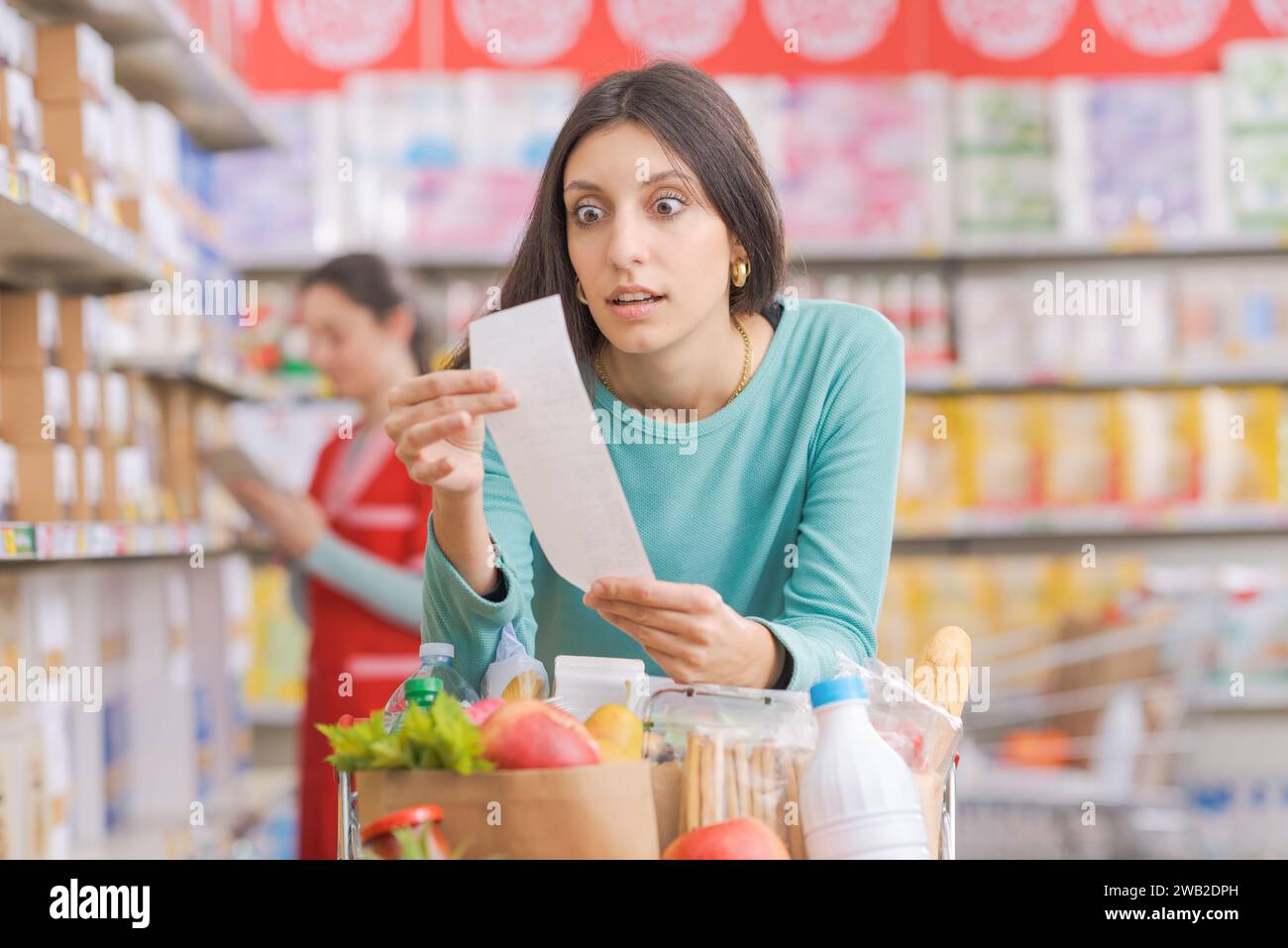 Young shocked woman at the supermarket, she is leaning on a shopping ...