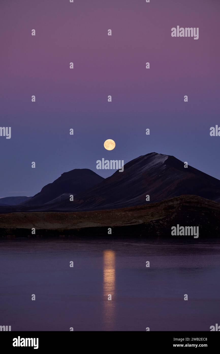 Moon over mountains and calm lake at night Stock Photo - Alamy