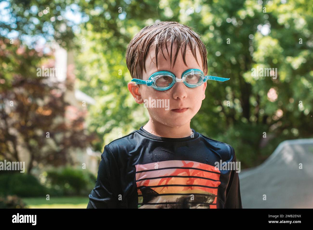 Close portrait of wet, cross-eyed young boy wearing goggles Stock Photo ...