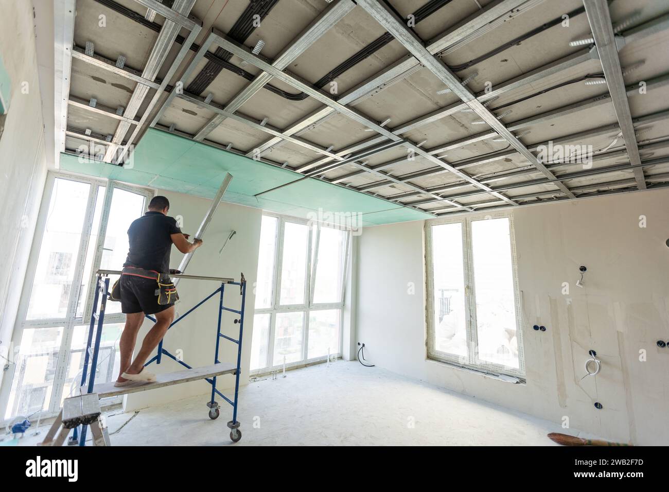 Drywall Installers. Men holding a gypsum board figured cut Stock Photo ...