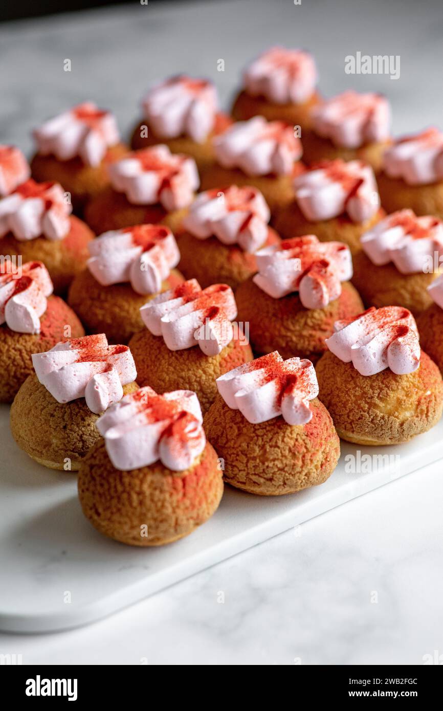 Eclair choux with pink frosting and a red berry powder Stock Photo - Alamy