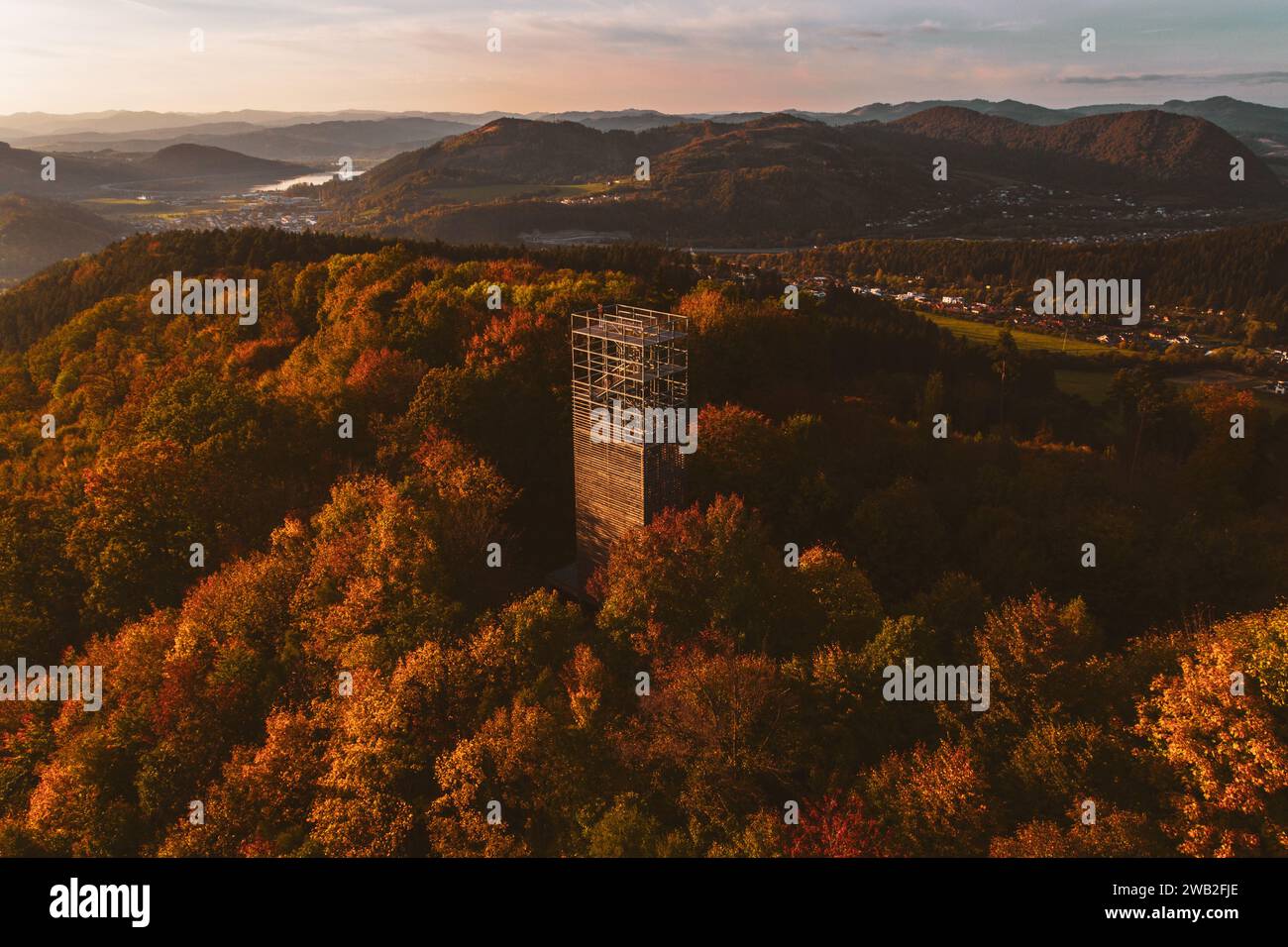 Aerial view of a wooden lookout tower in autumn nature. People stand on ...
