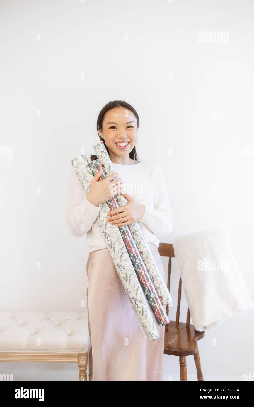 Girl holding Wrapping Paper Bundles in a Minimal White Studio Stock ...