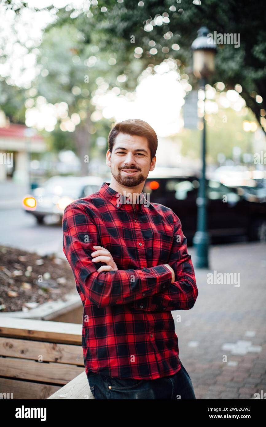 Vertical image of young guy standing downtown at sunset Stock Photo - Alamy