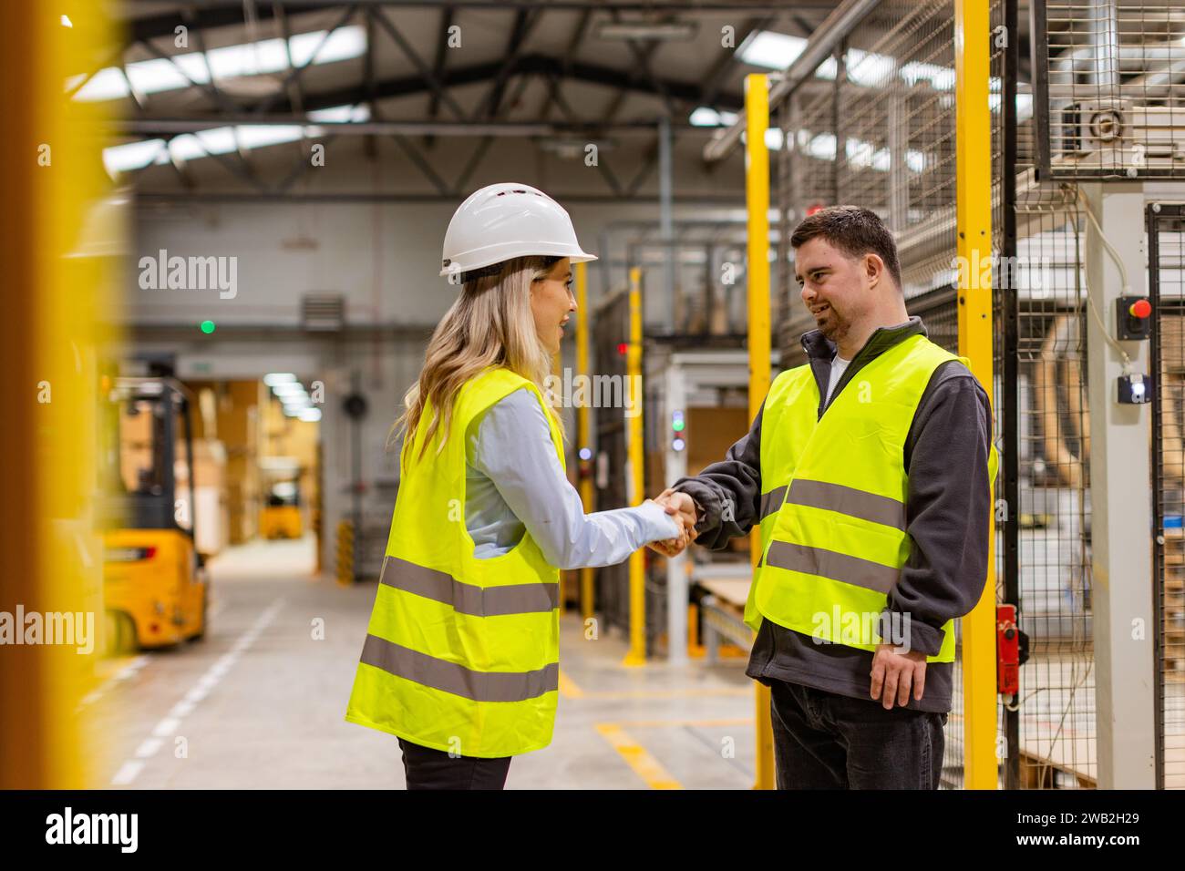 Young man with Down syndrome shaking hands with manager in modern ...