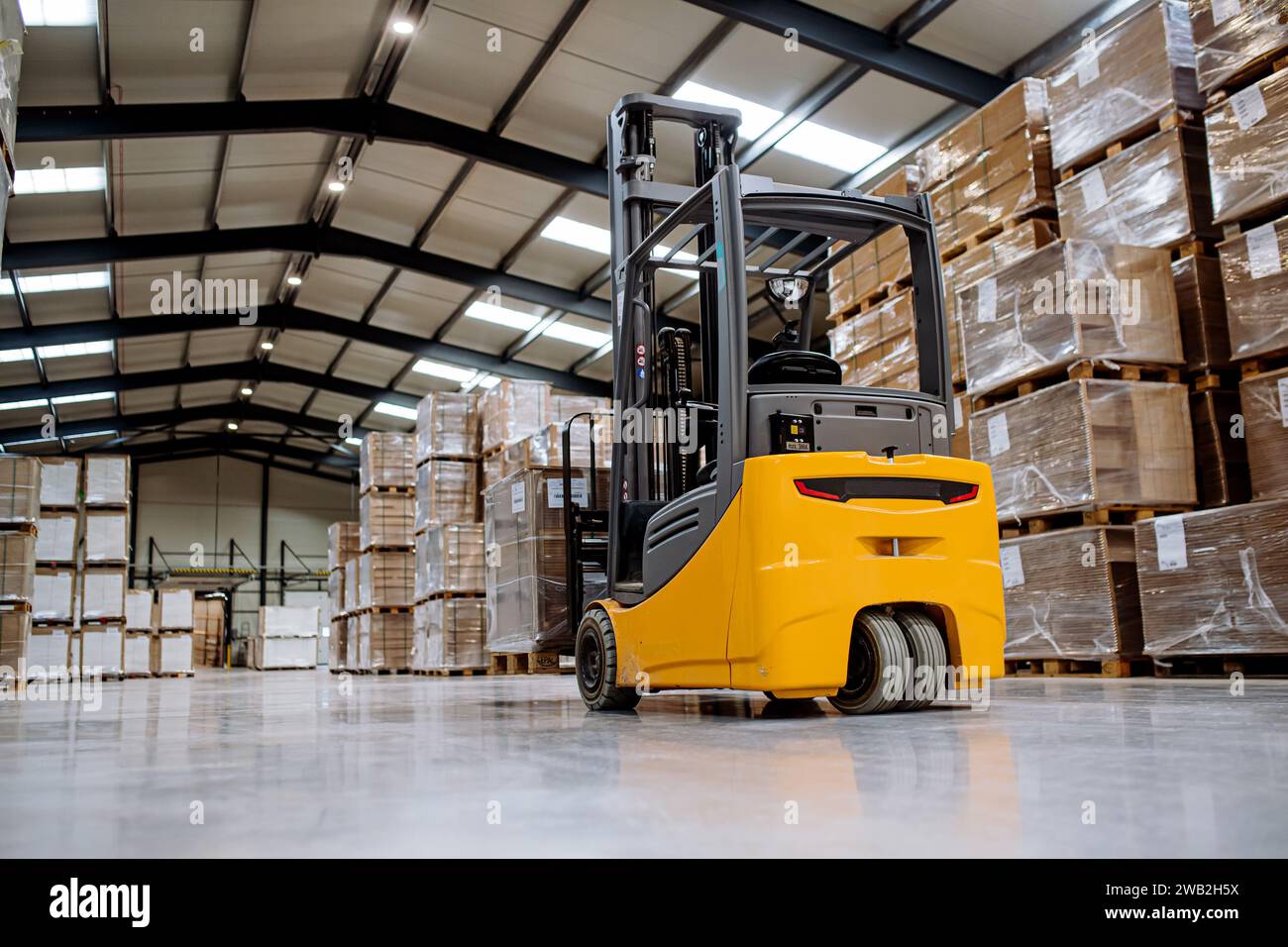 Back view of forklift in warehouse in the middle of stored goods ...